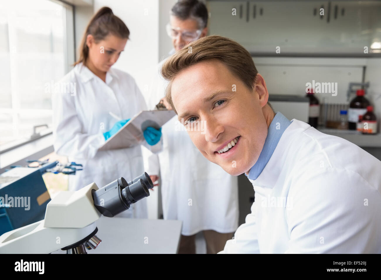 Scientist looking through a microscope Stock Photo - Alamy