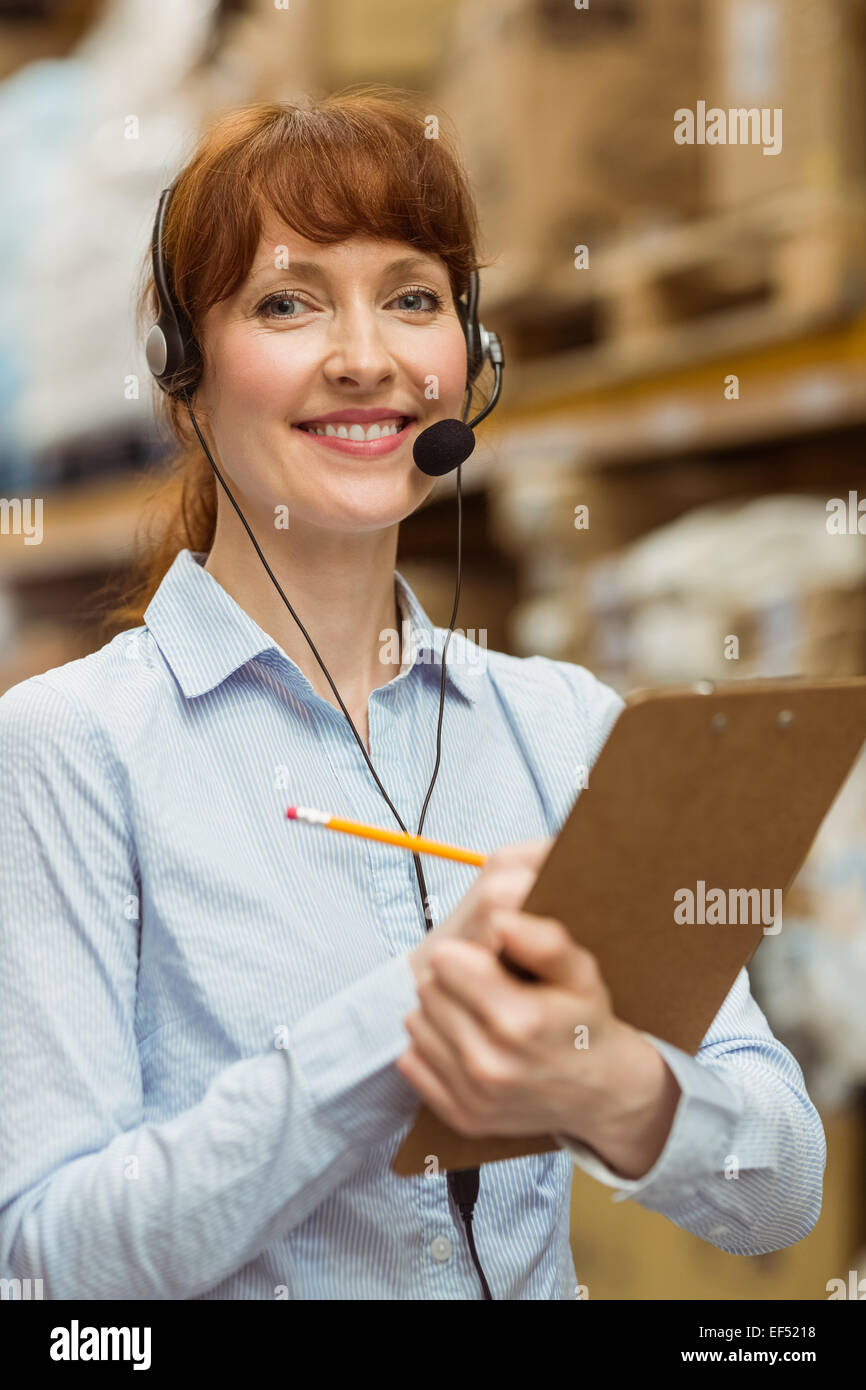 Warehouse manager writing on clipboard Stock Photo - Alamy