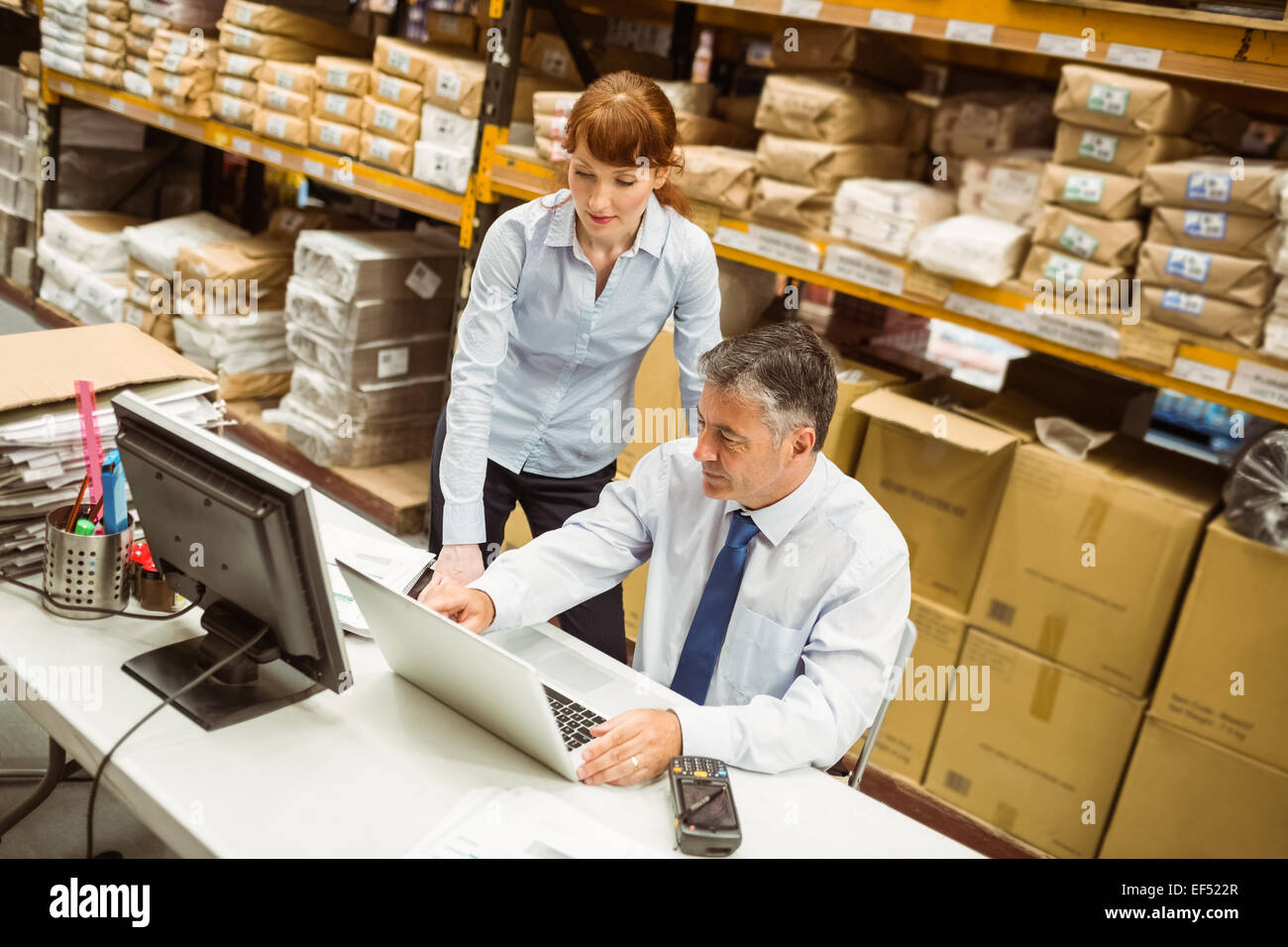 Warehouse managers working together on laptop Stock Photo - Alamy