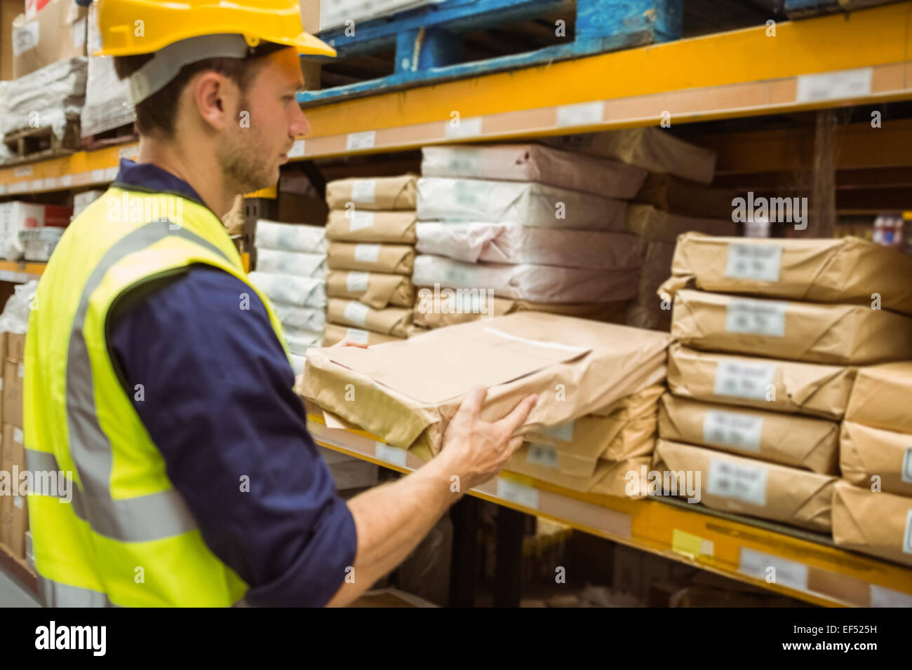 Warehouse worker taking package in the shelf Stock Photo - Alamy
