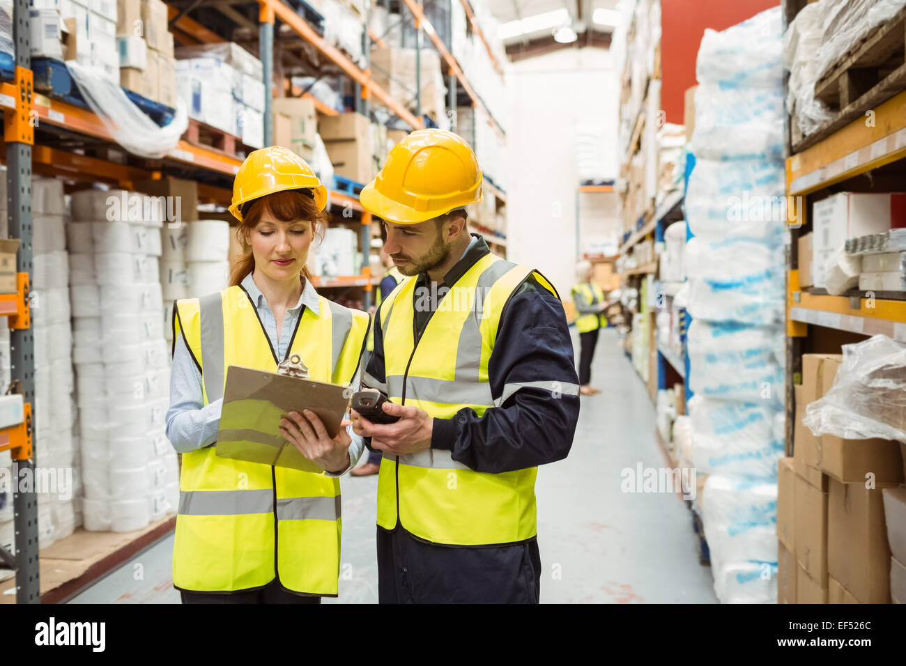 Warehouse manager talking with worker Stock Photo - Alamy