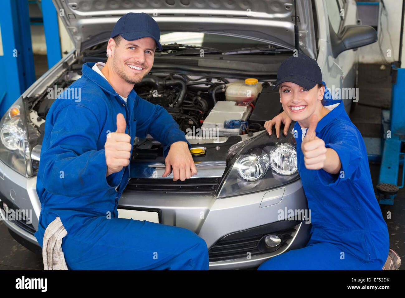 Team of mechanics smiling at camera Stock Photo - Alamy