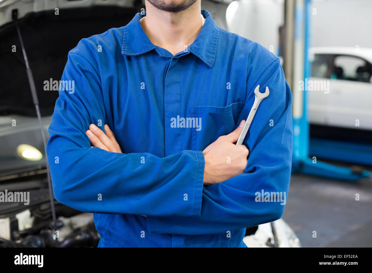 Mechanic standing with arms crossed Stock Photo - Alamy