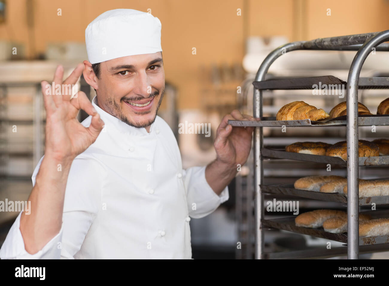 Positive baker checking freshly baked bread Stock Photo - Alamy