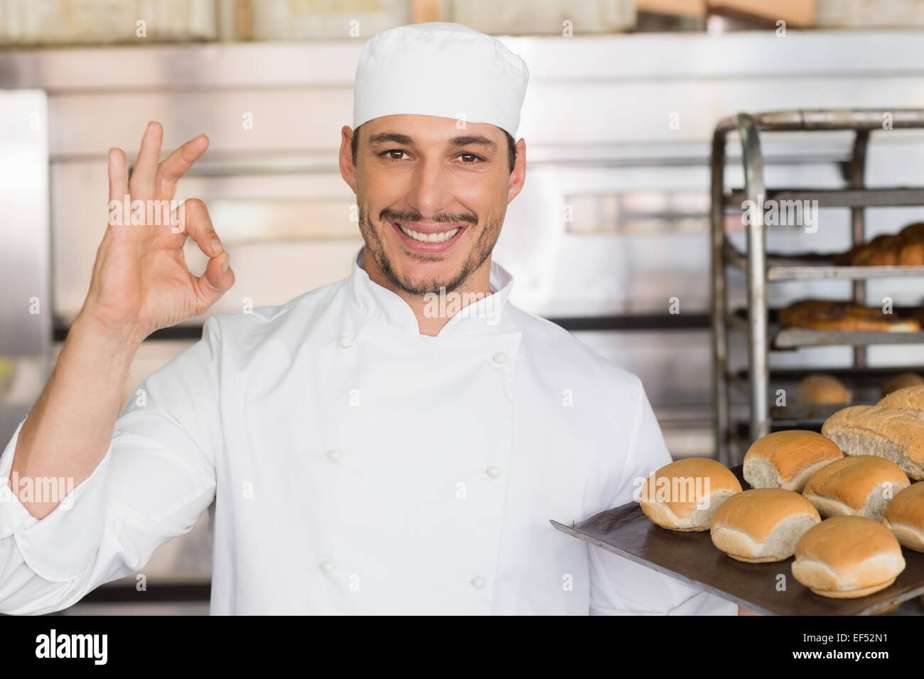 Happy baker showing tray of fresh bread Stock Photo - Alamy