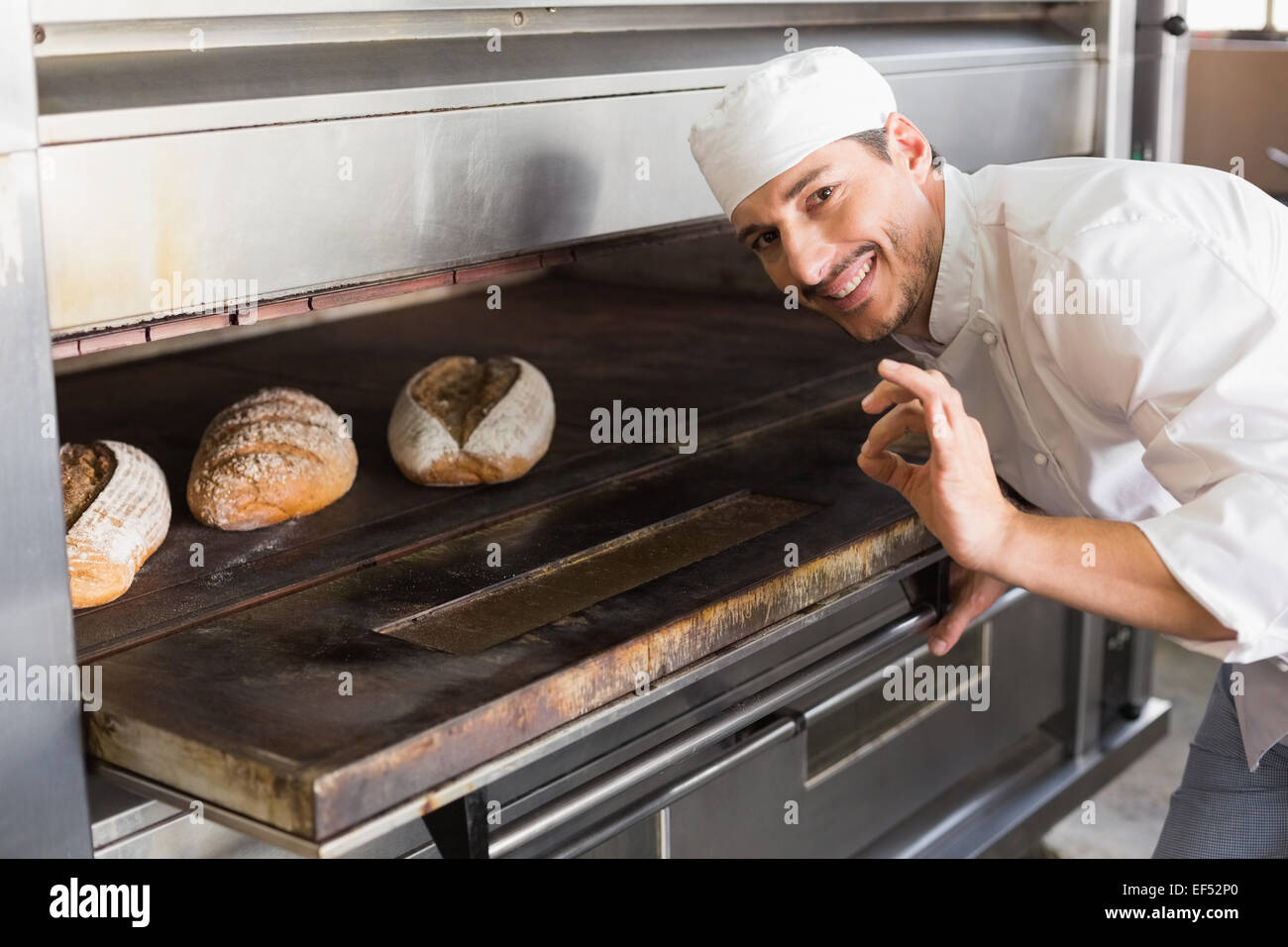 Happy baker by open oven Stock Photo - Alamy