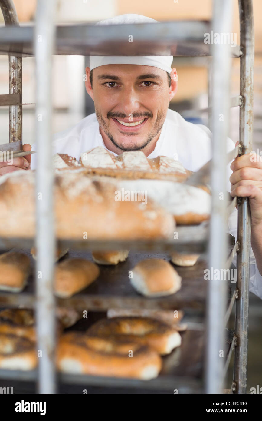 Smiling baker holding tray of raw dough Stock Photo - Alamy