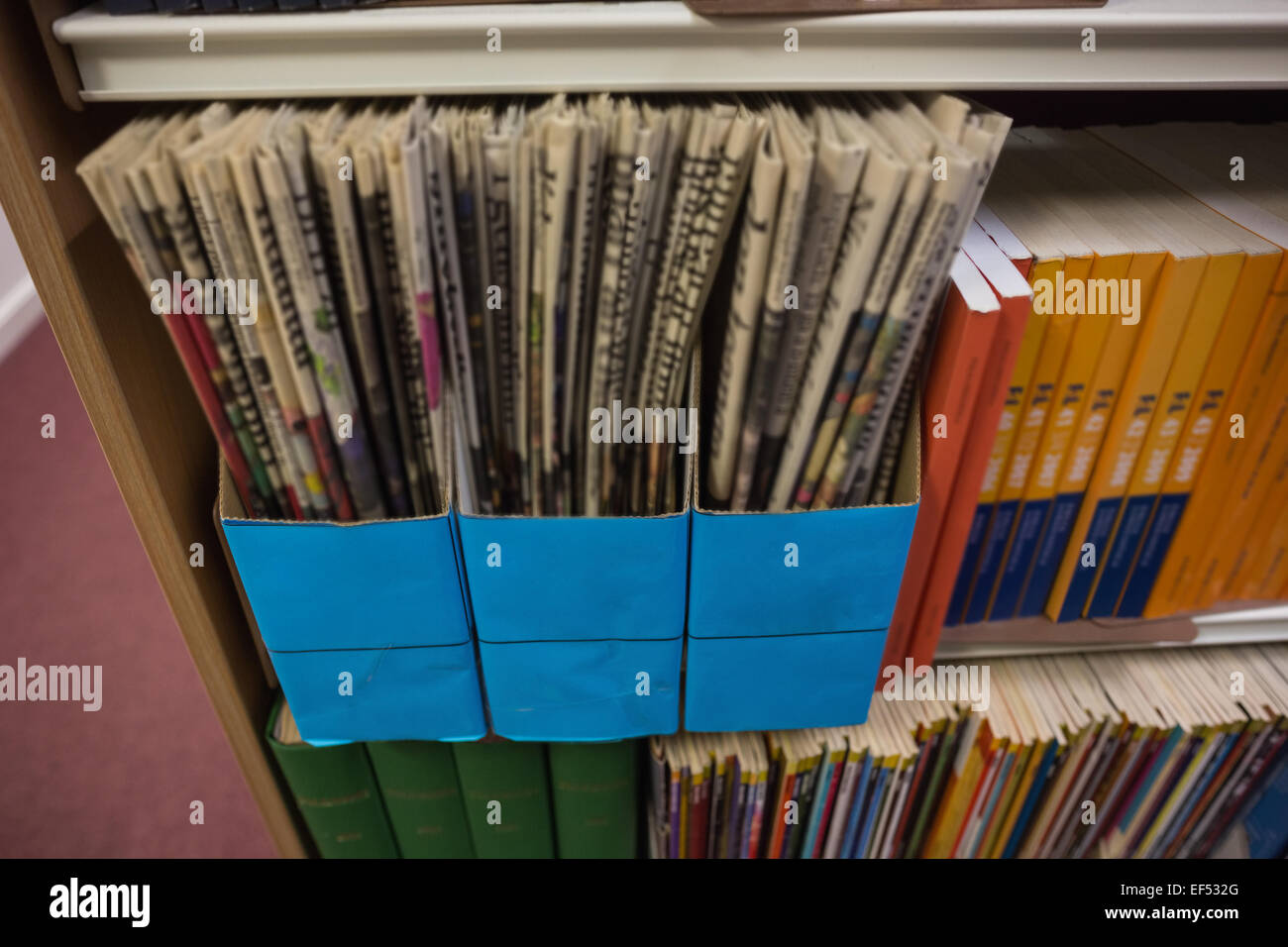 Newspapers on bookshelf in library Stock Photo - Alamy