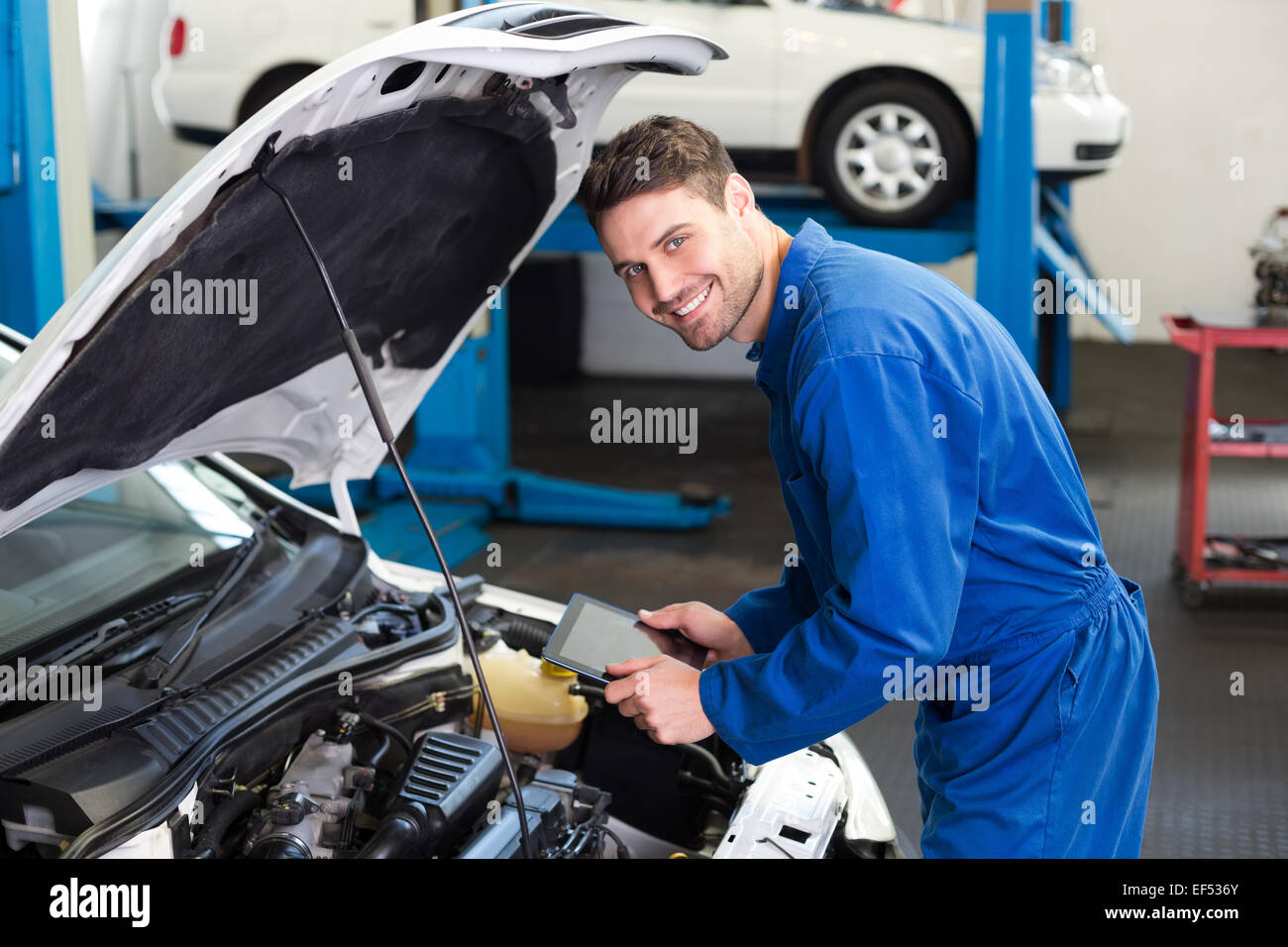 Mechanic using tablet to fix car Stock Photo - Alamy
