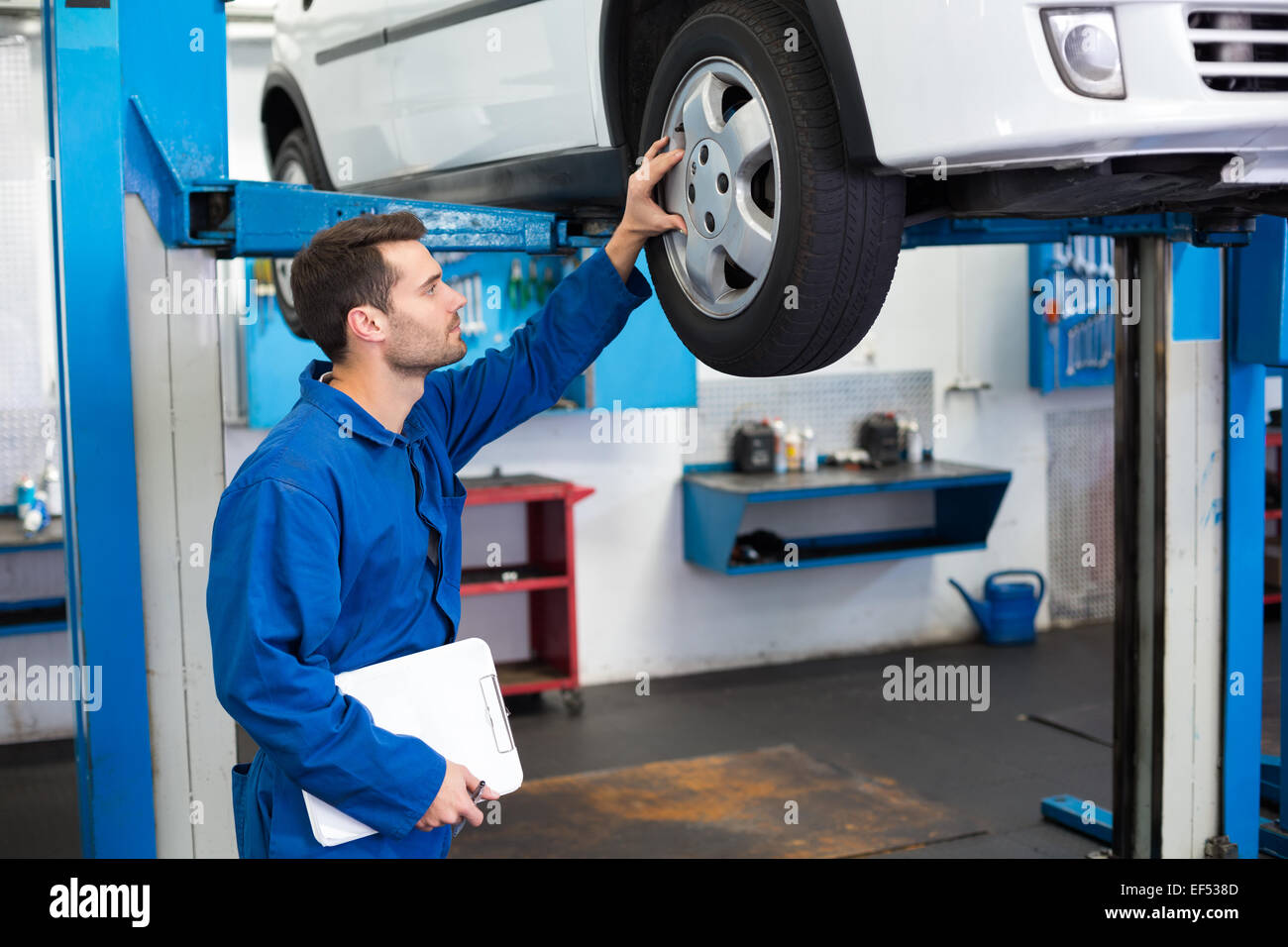 Mechanic looking at car tires Stock Photo - Alamy