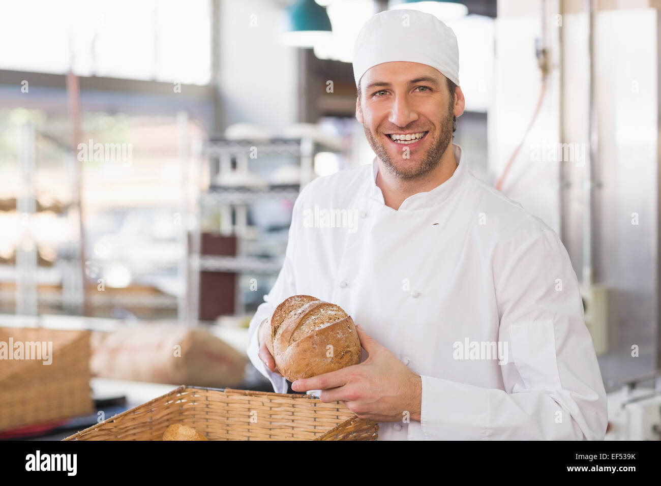 Happy baker with loaf of bread Stock Photo - Alamy