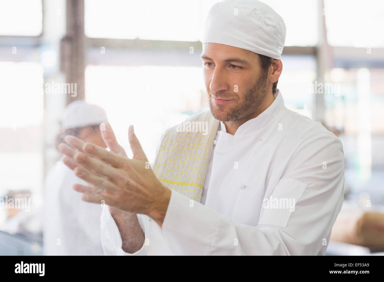 Baker clapping flour from his hands Stock Photo - Alamy