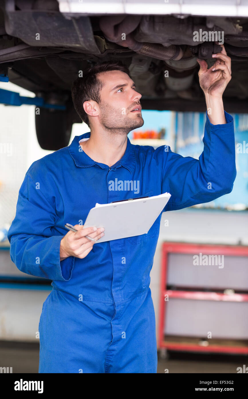 Mechanic examining under the car Stock Photo - Alamy