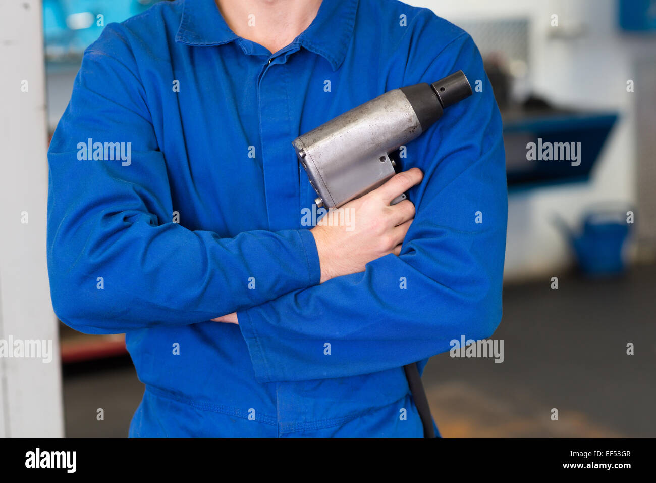 Mechanic holding a drill tool Stock Photo - Alamy