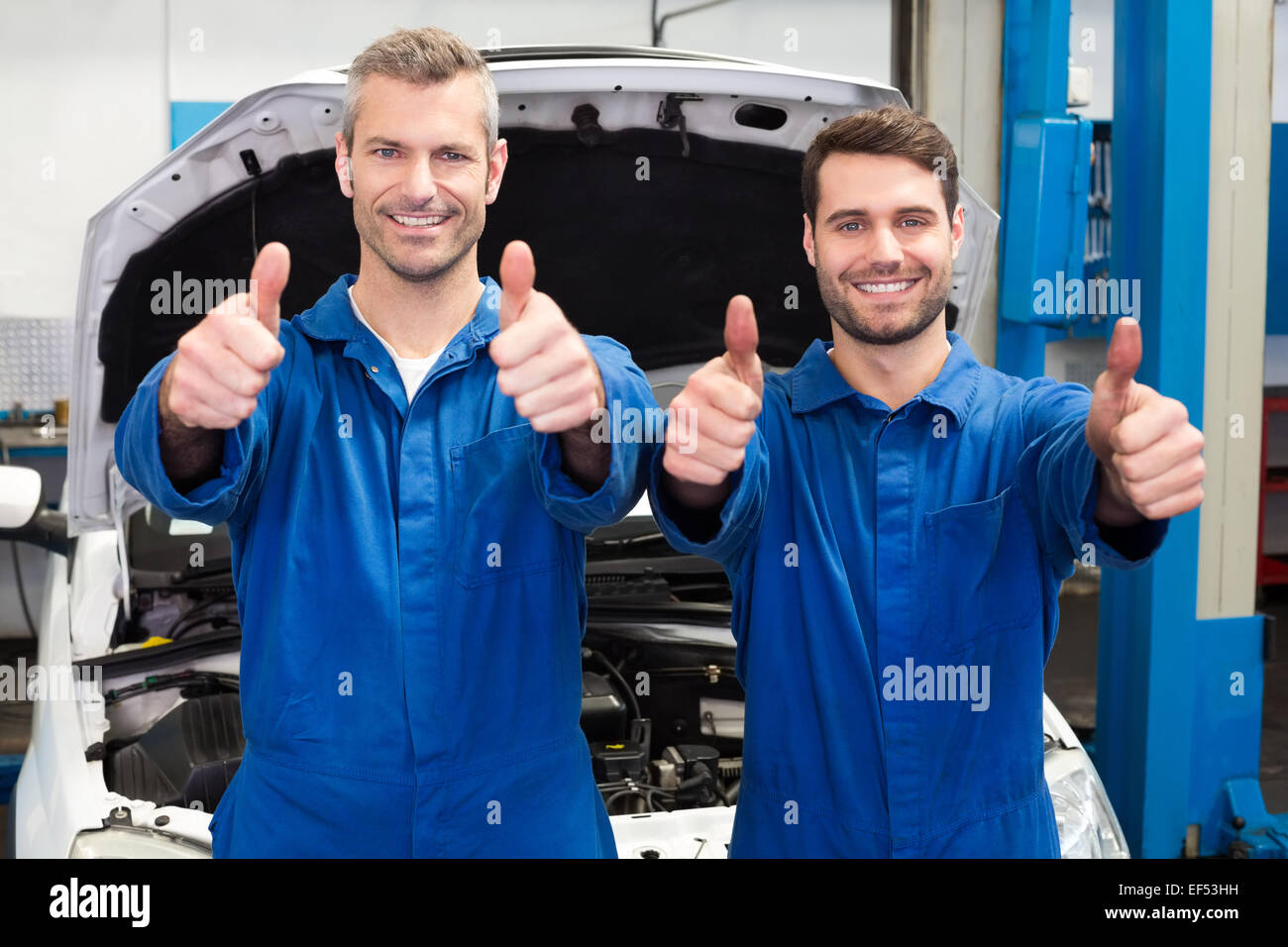 Team of mechanics smiling at camera Stock Photo - Alamy