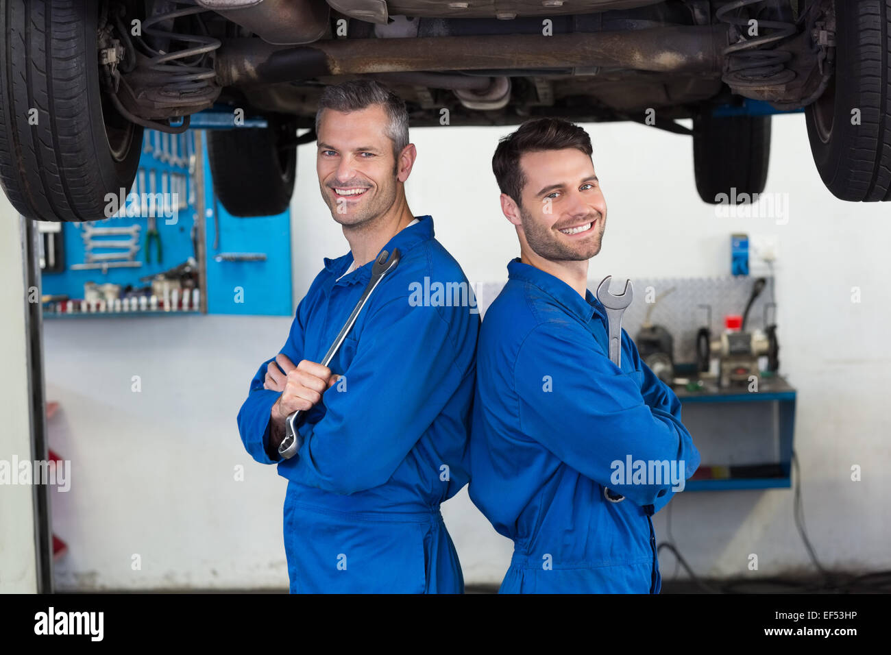 Team of mechanics smiling at camera Stock Photo - Alamy