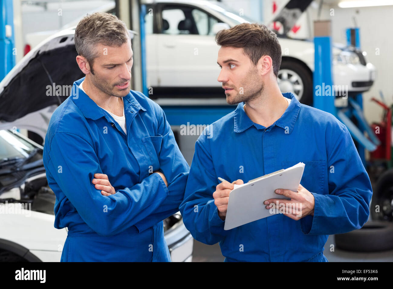Team of mechanics talking together Stock Photo - Alamy