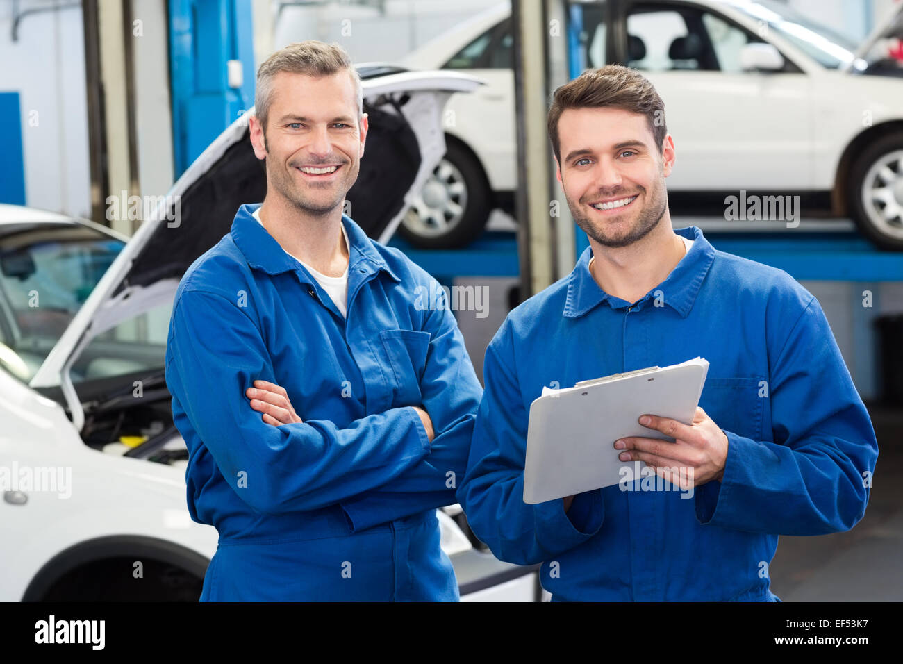 Team of mechanics smiling at camera Stock Photo - Alamy