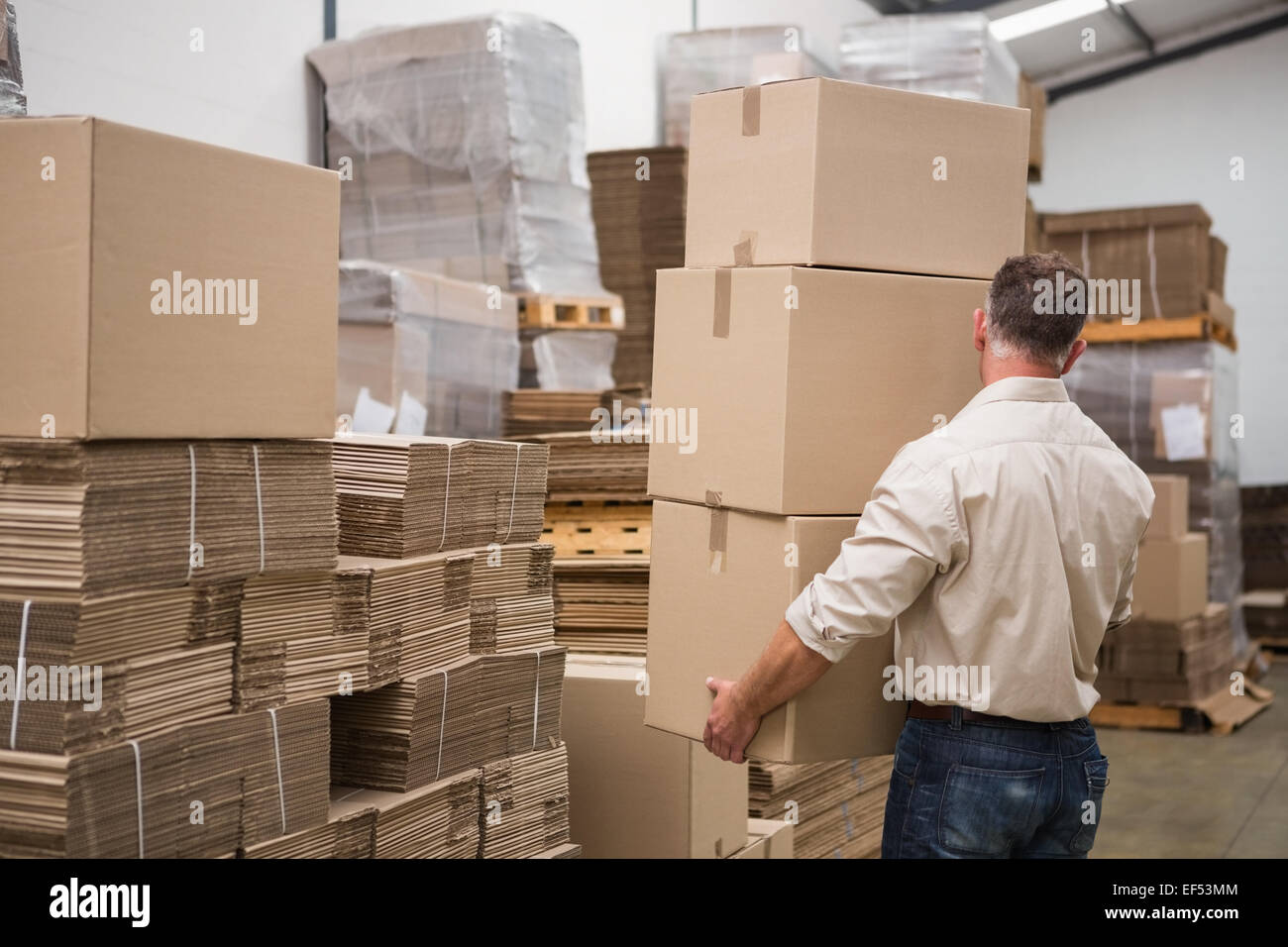 Rear view of worker carrying boxes Stock Photo - Alamy