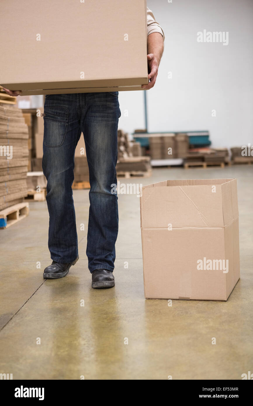 Worker with box in warehouse Stock Photo - Alamy