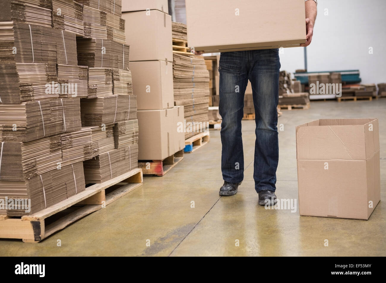Worker with box in warehouse Stock Photo - Alamy