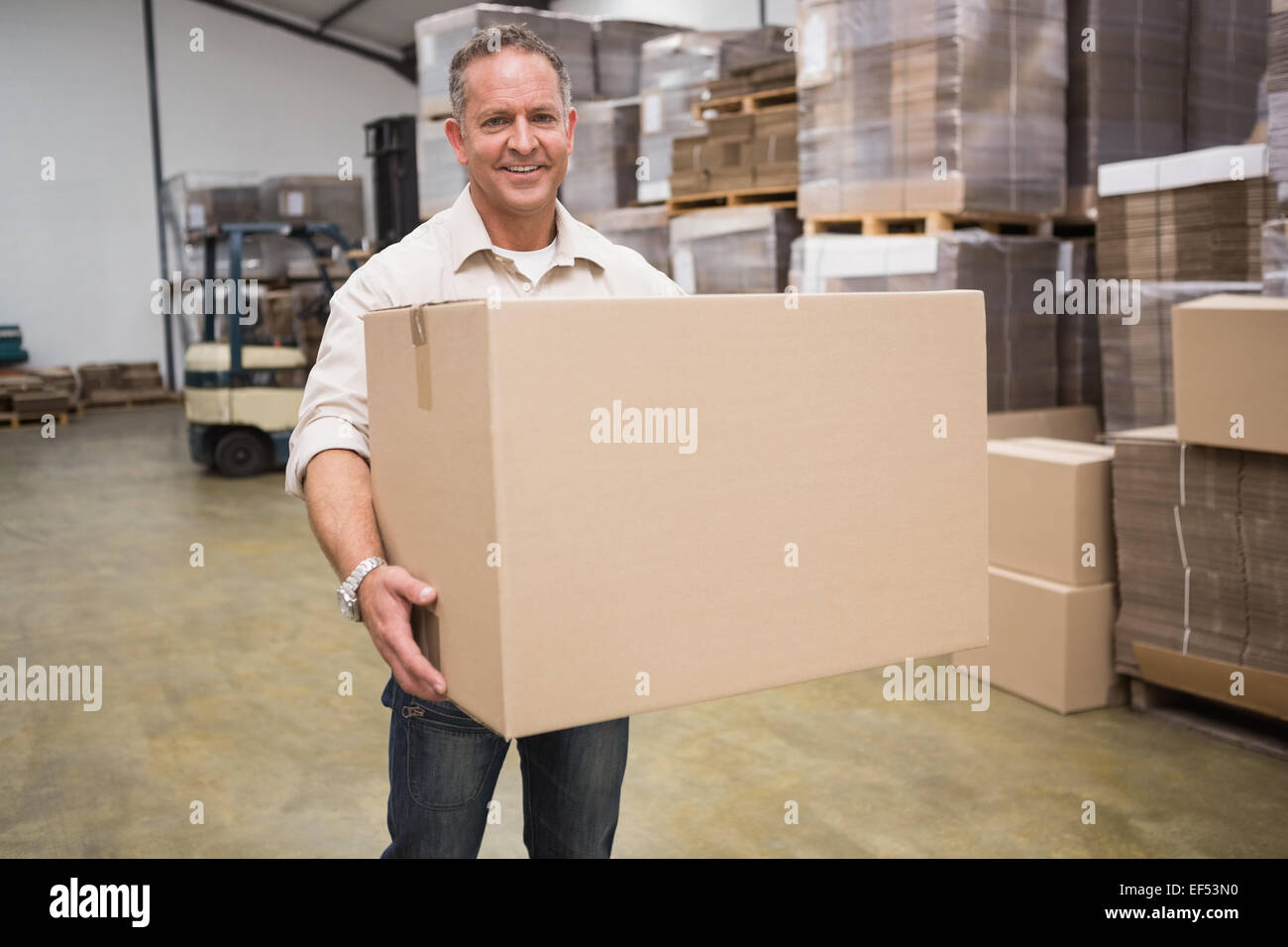 Portrait of worker carrying box Stock Photo - Alamy