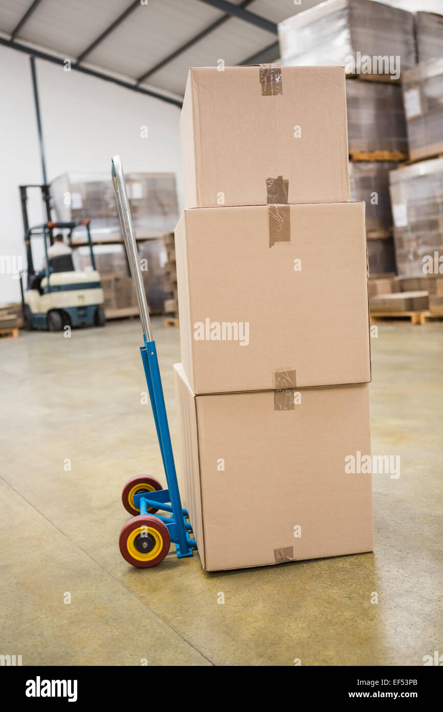 Boxes on trolley in warehouse Stock Photo - Alamy