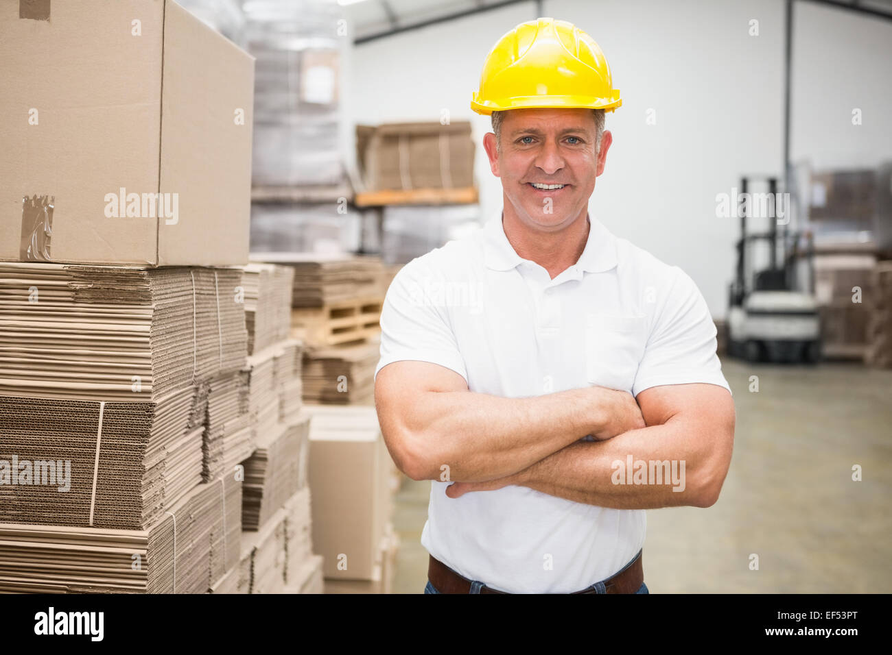 Worker wearing hard hat in warehouse Stock Photo - Alamy