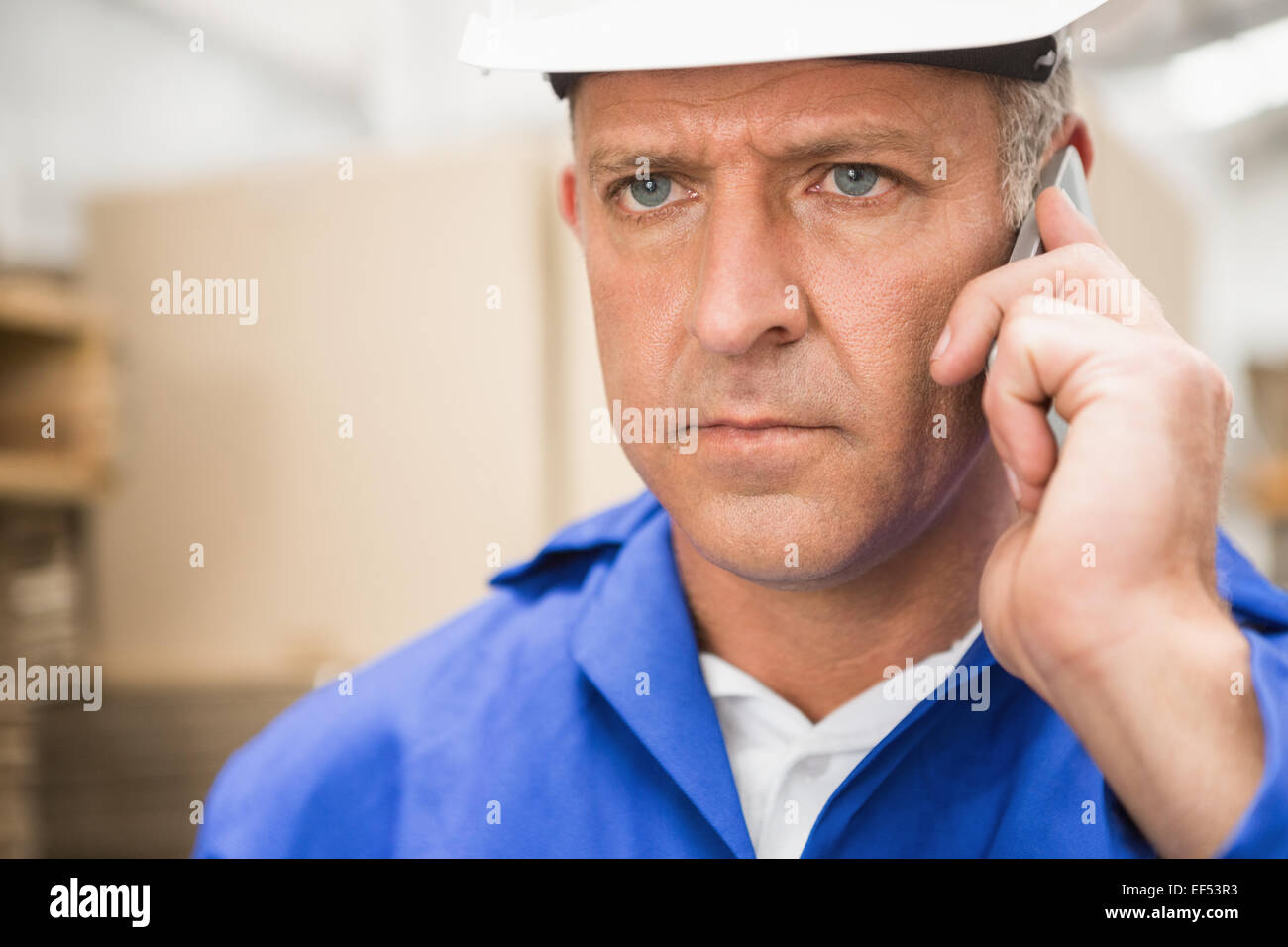 Worker using mobile phone in warehouse Stock Photo - Alamy