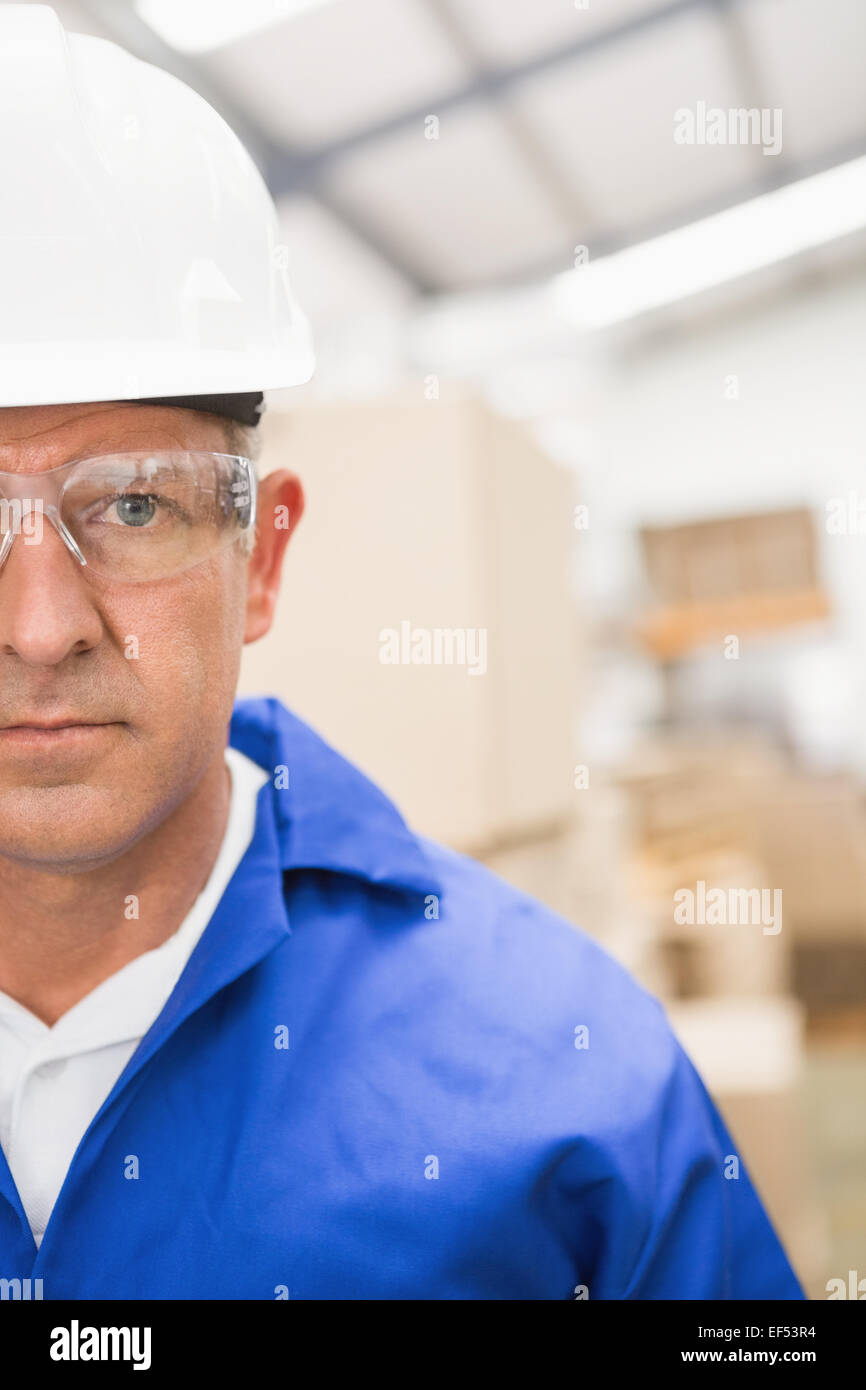 Worker wearing hard hat in warehouse Stock Photo - Alamy