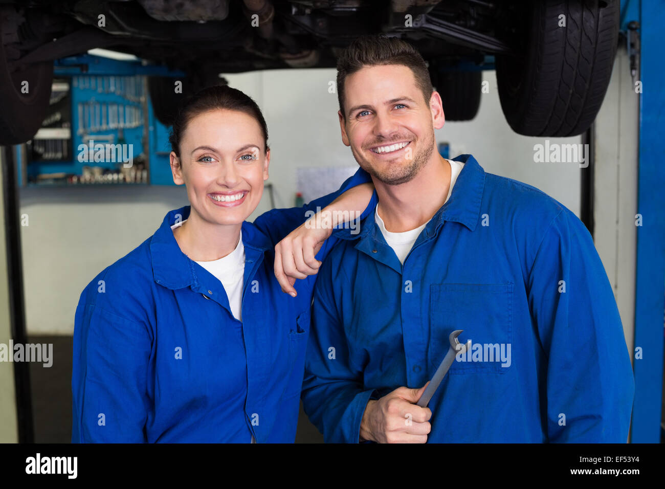 Team of mechanics smiling at camera Stock Photo - Alamy