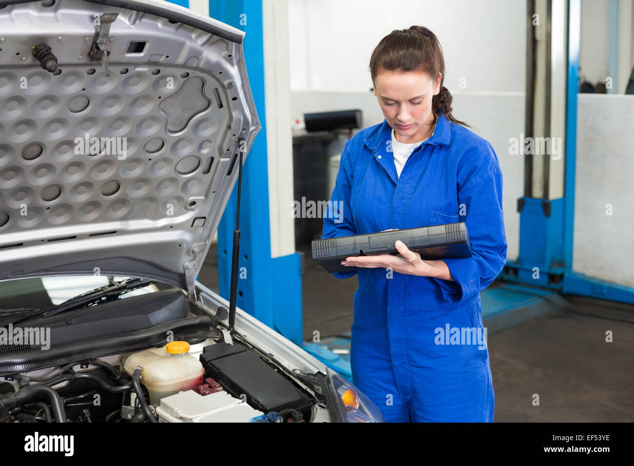 Mechanic examining under hood of car Stock Photo - Alamy