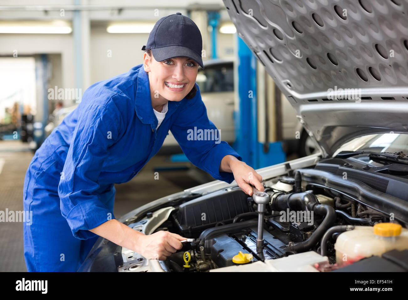 Smiling mechanic working on car Stock Photo - Alamy