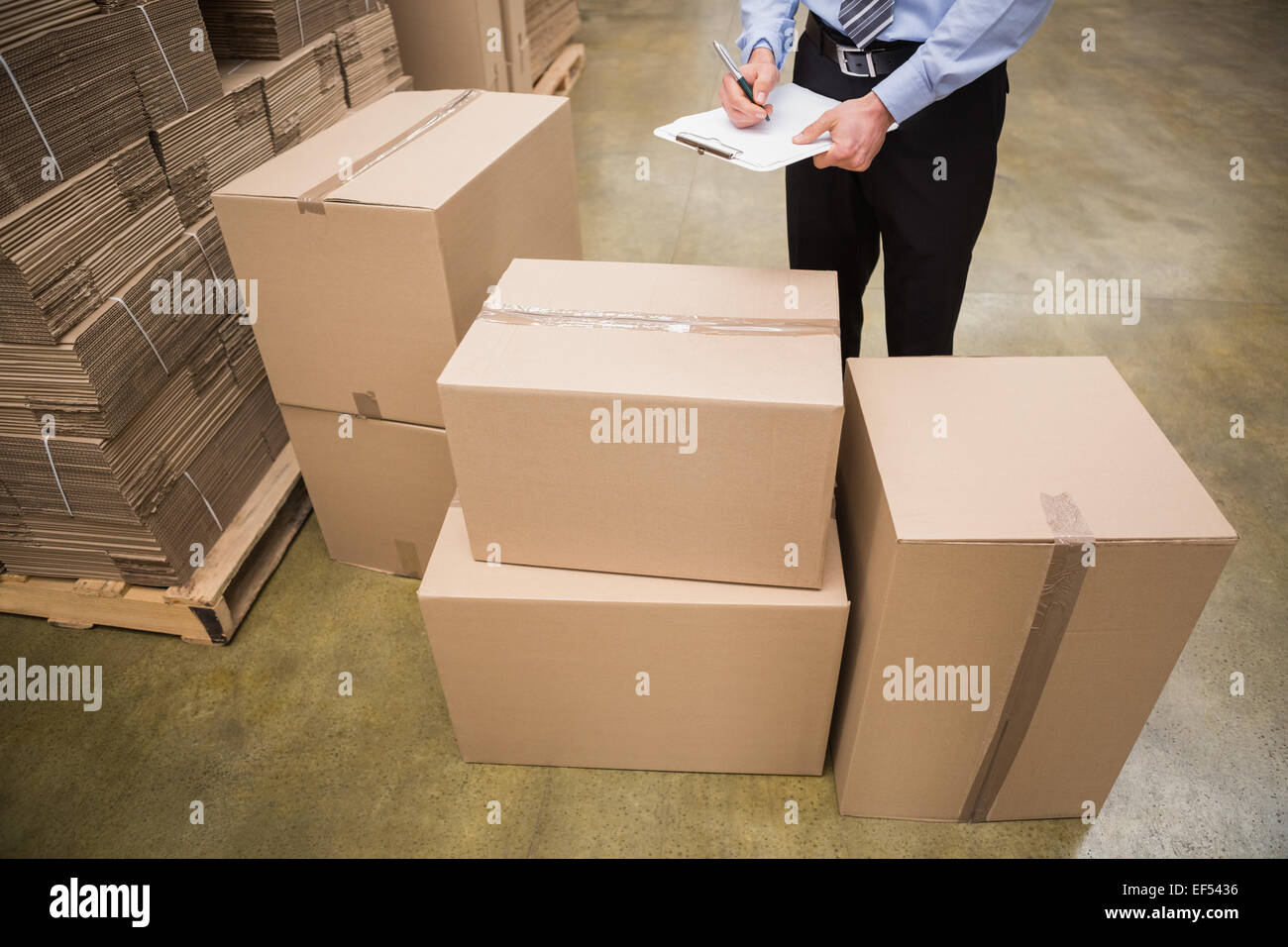Warehouse worker checking his list on clipboard Stock Photo - Alamy