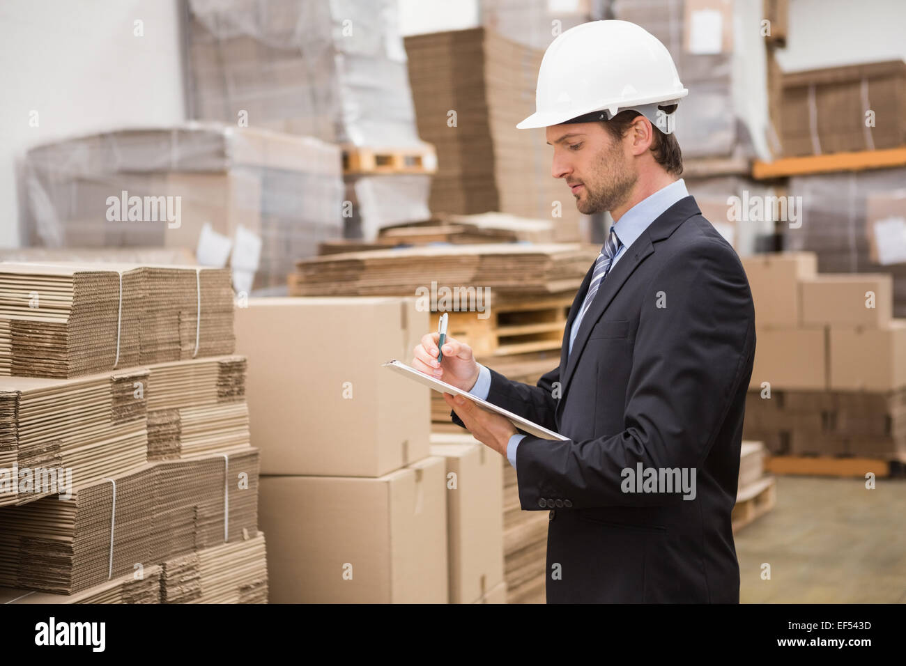 Serious warehouse manager checking inventory Stock Photo - Alamy