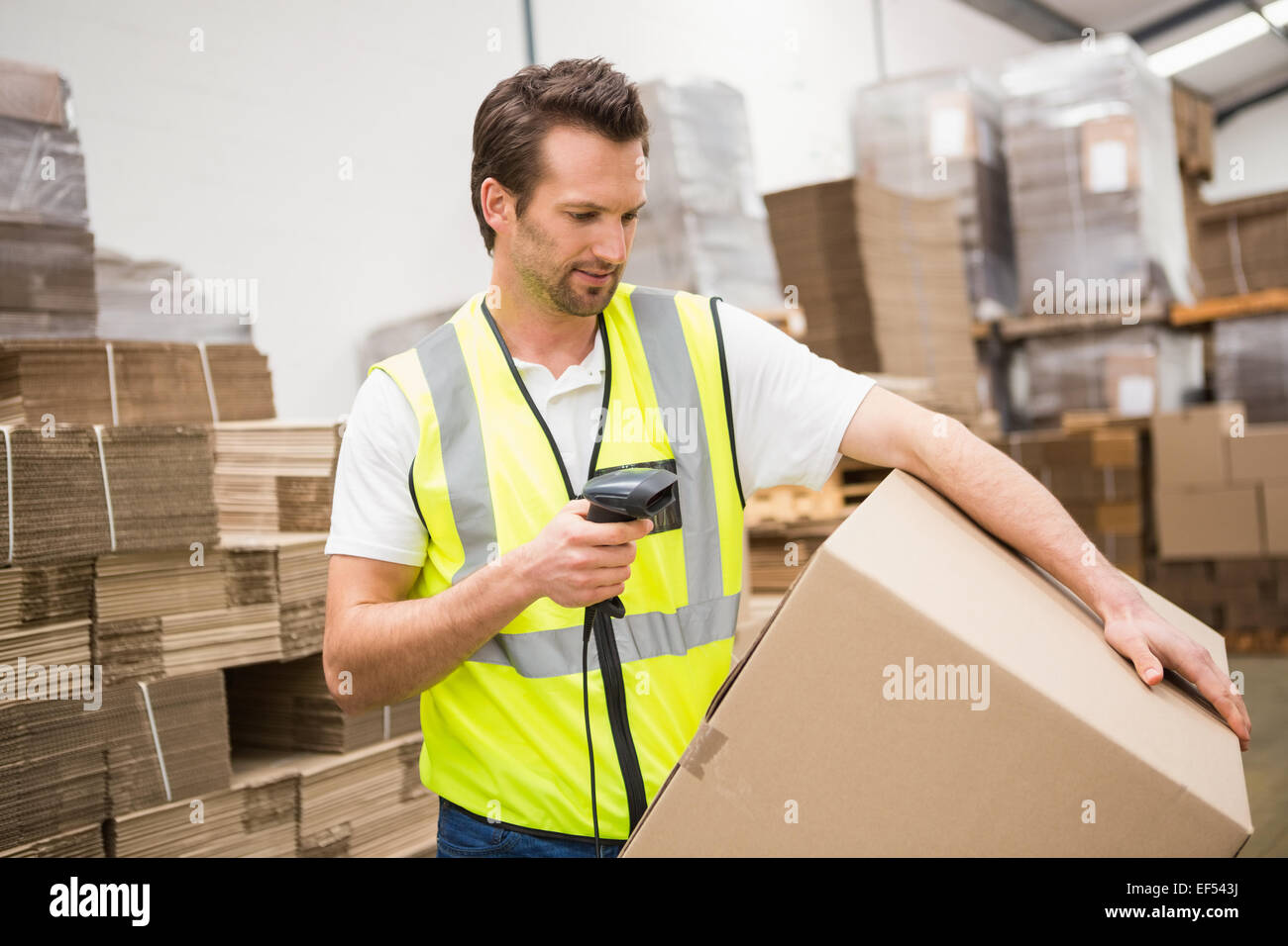 Worker scanning package in warehouse Stock Photo - Alamy