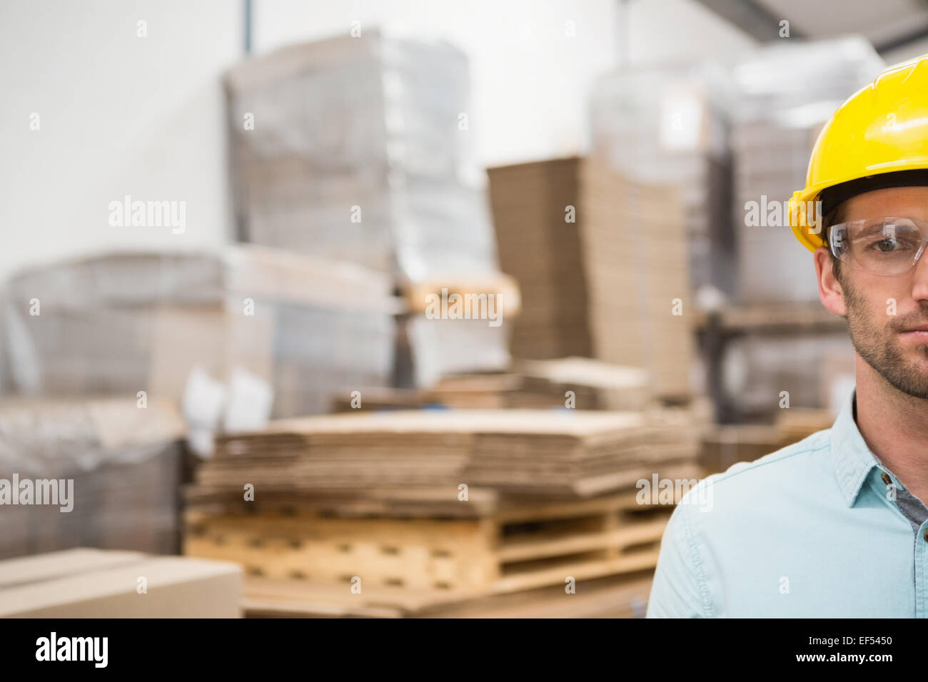 Close up of worker wearing hard hat in warehouse Stock Photo - Alamy