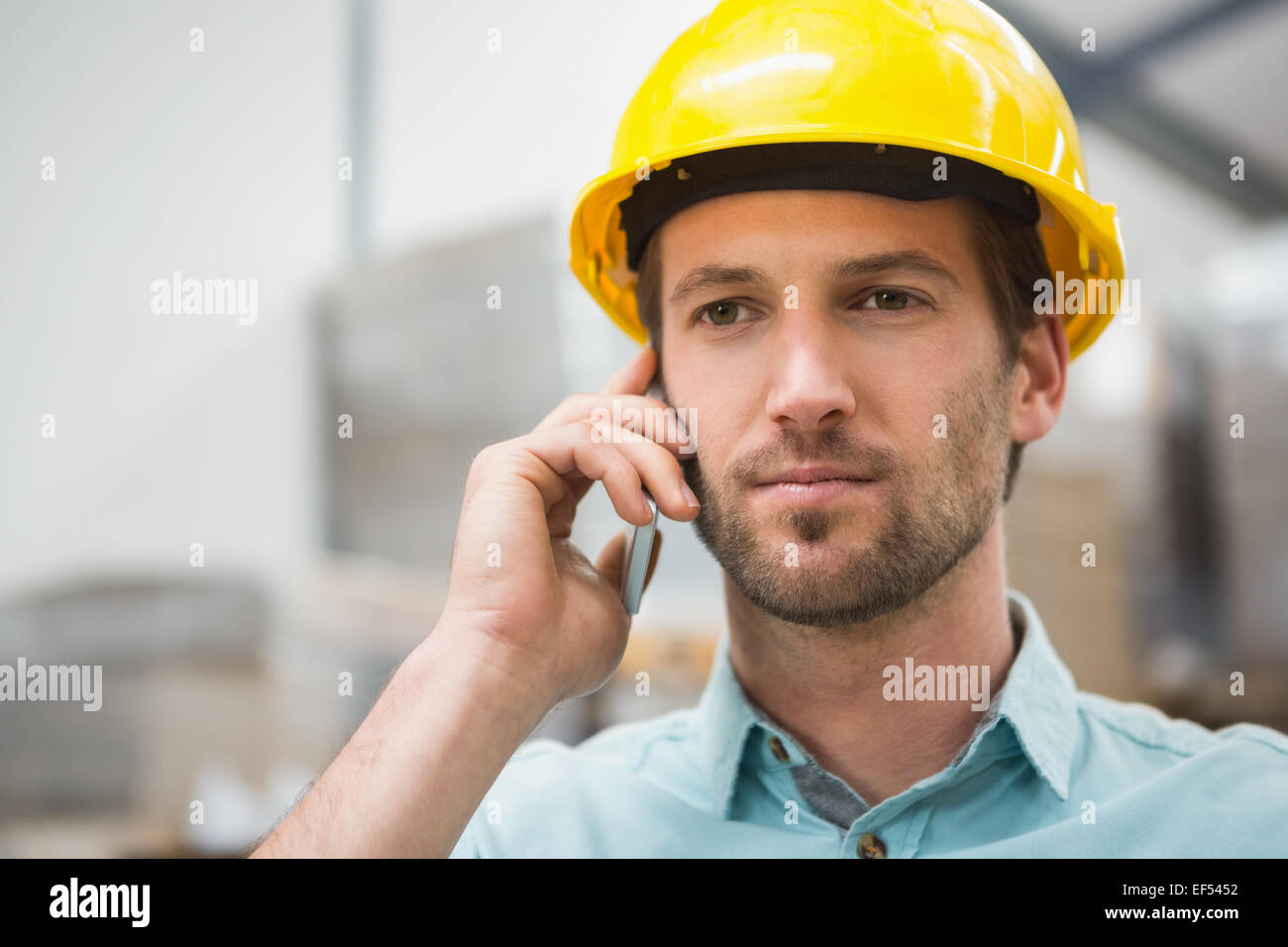 Worker using mobile phone in warehouse Stock Photo - Alamy