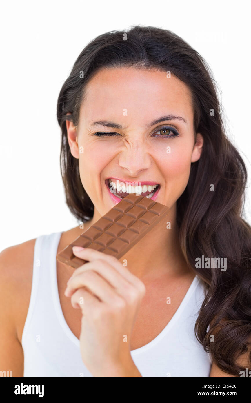 Pretty brunette eating bar of chocolate Stock Photo - Alamy