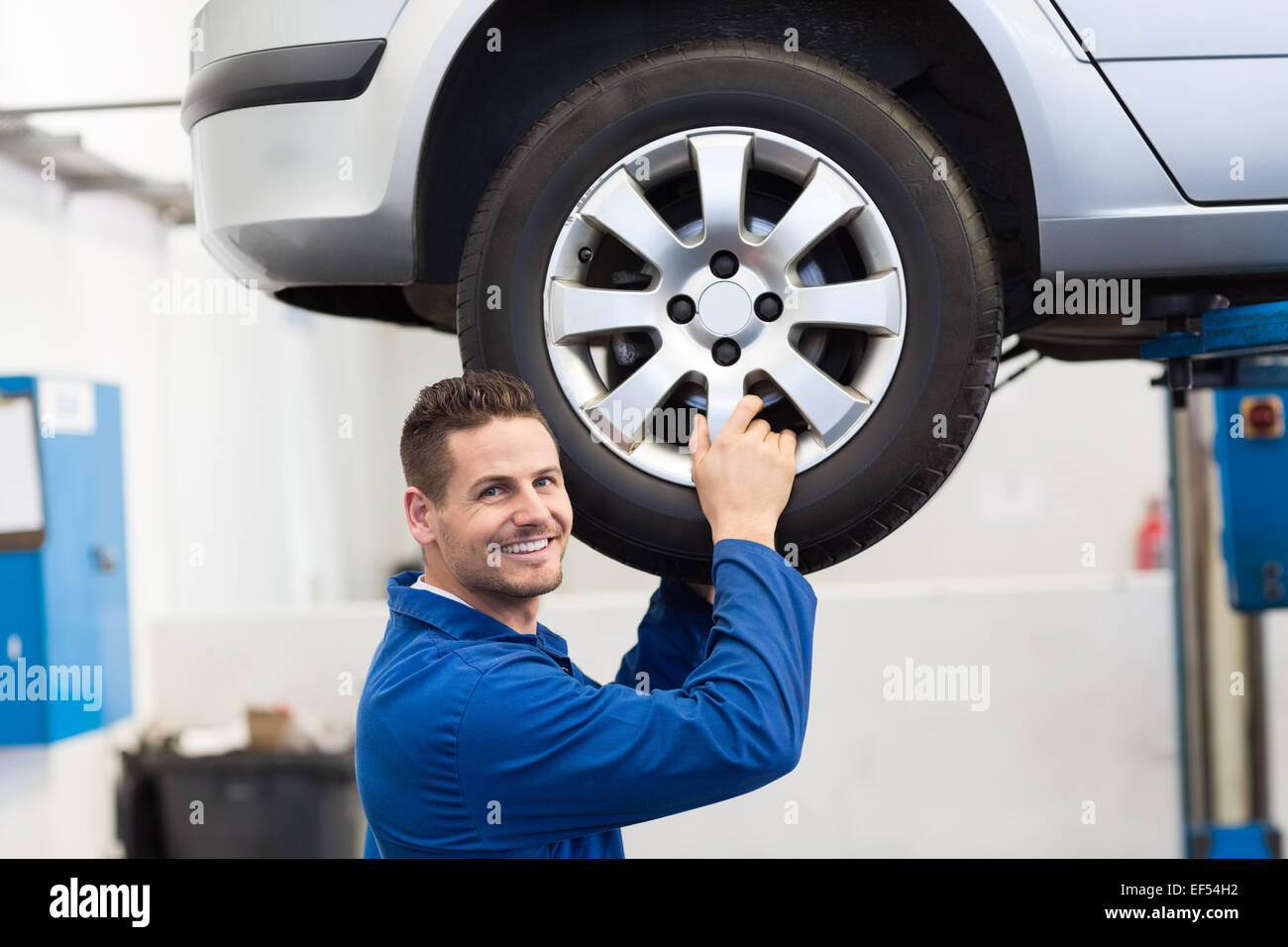 Mechanic adjusting the tire wheel Stock Photo - Alamy