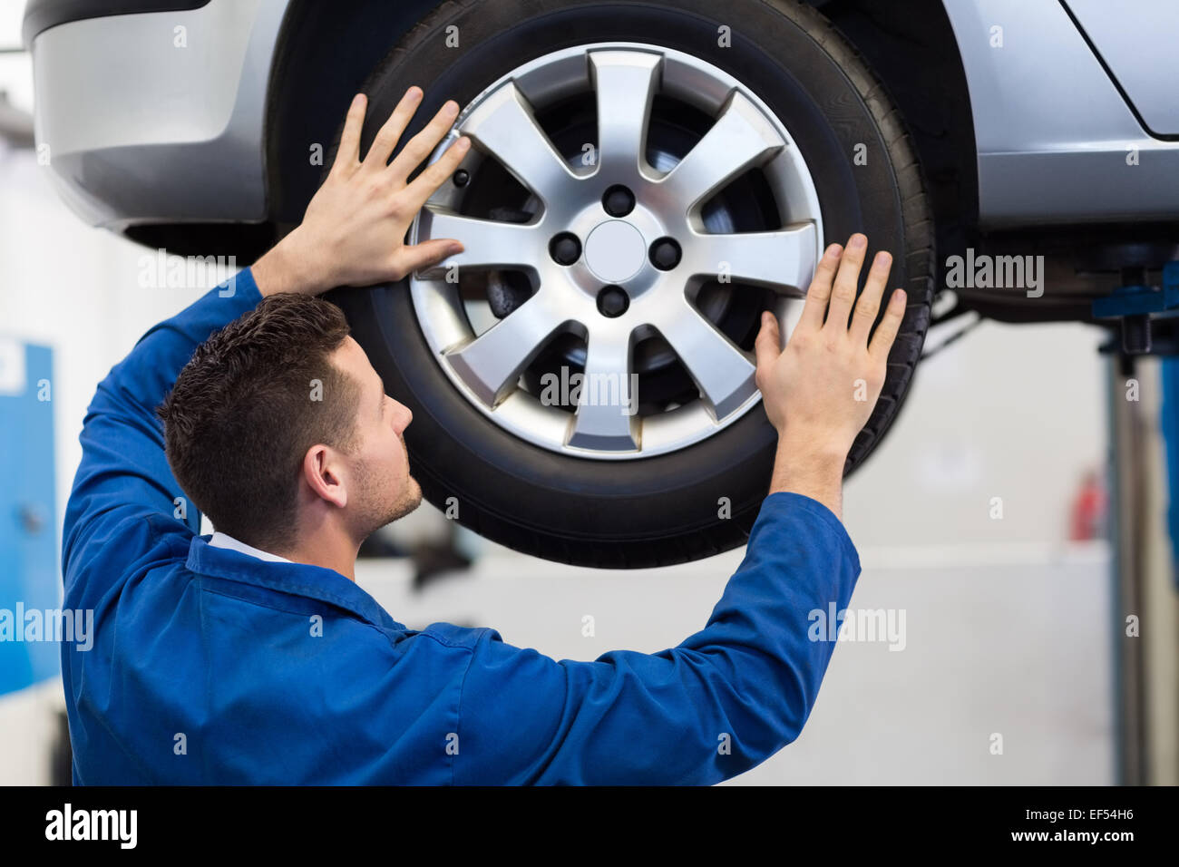 Mechanic adjusting the tire wheel Stock Photo - Alamy