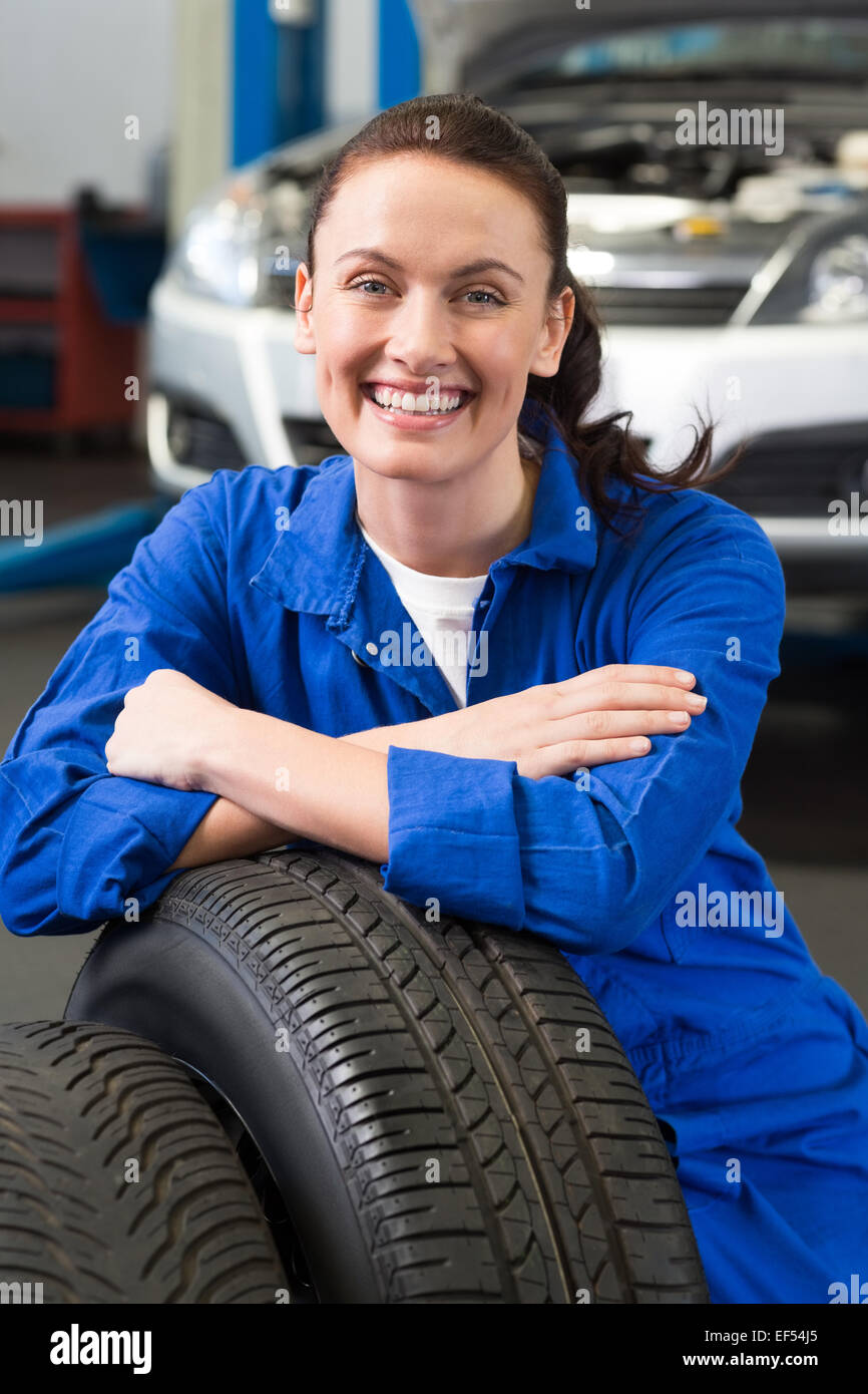 Mechanic smiling at the camera with tire Stock Photo - Alamy