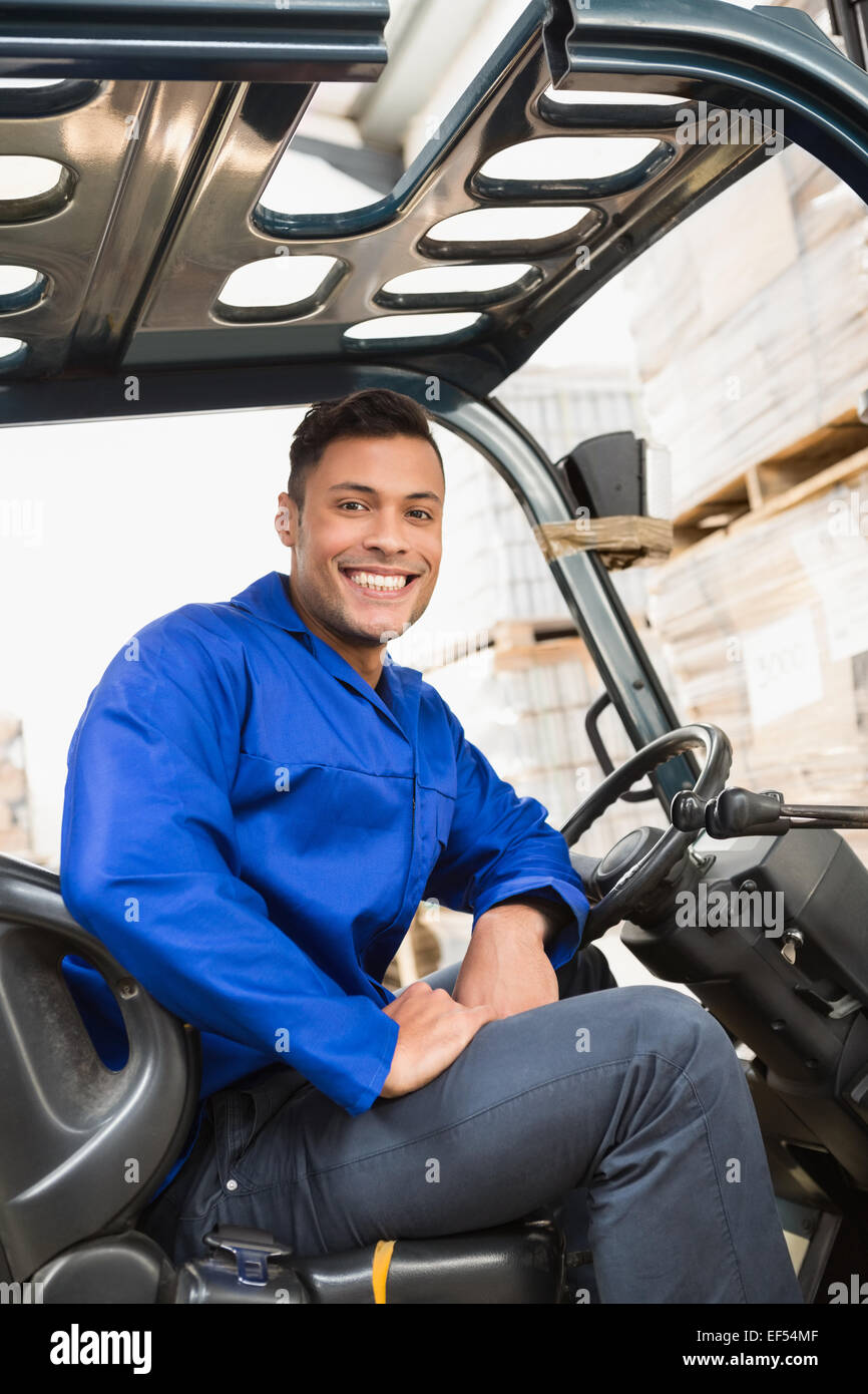 Driver operating forklift machine in warehouse Stock Photo - Alamy