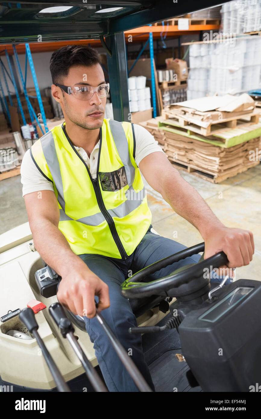 Driver operating forklift machine in warehouse Stock Photo - Alamy