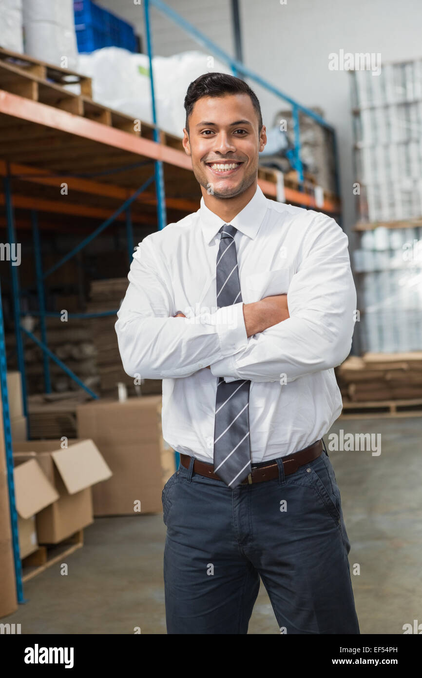 Smiling manager with arms crossed in warehouse Stock Photo - Alamy