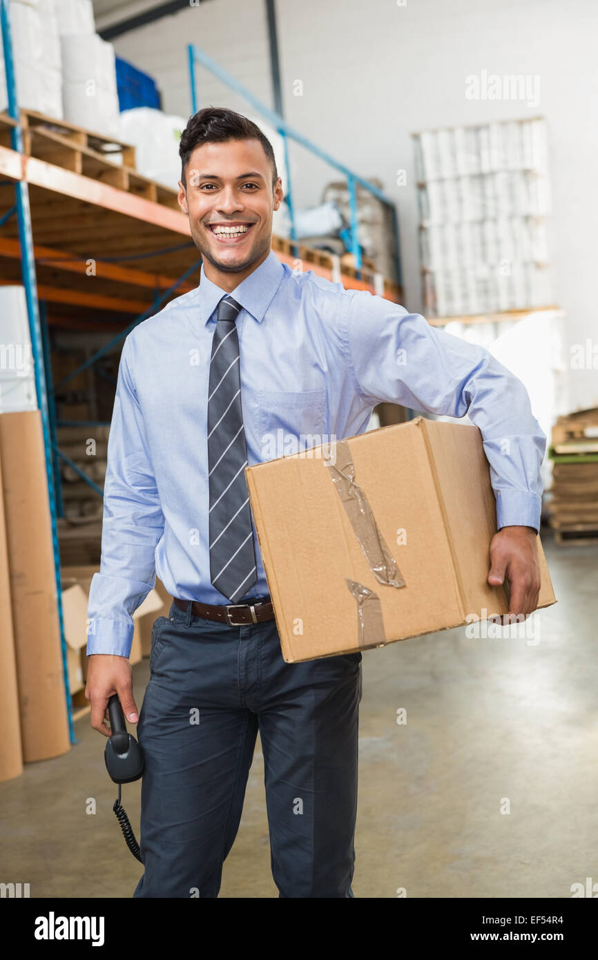 Warehouse manager holding cardboard box and scanner Stock Photo - Alamy