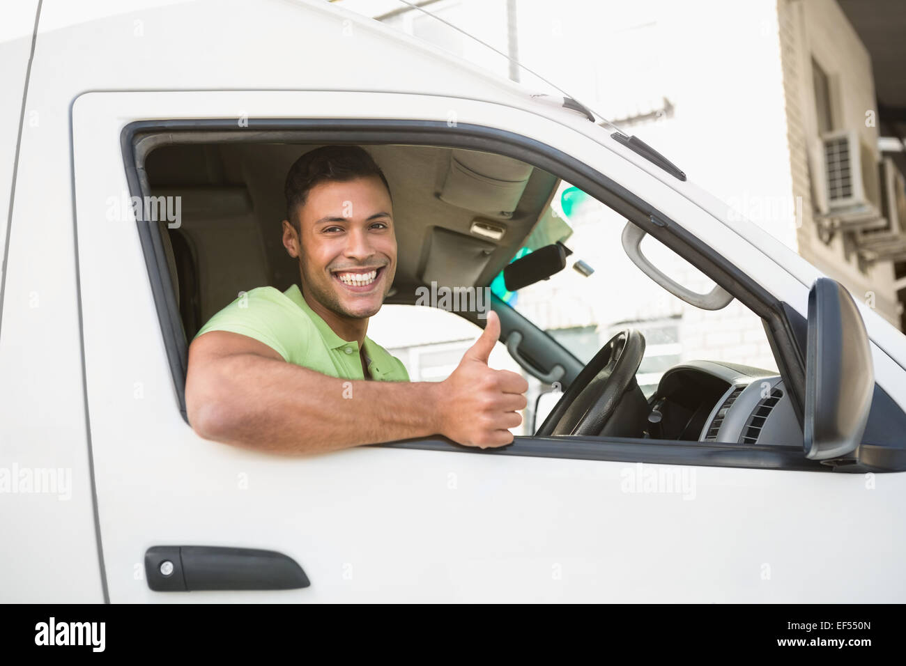 Smiling man showing thumbs up driving his van Stock Photo - Alamy