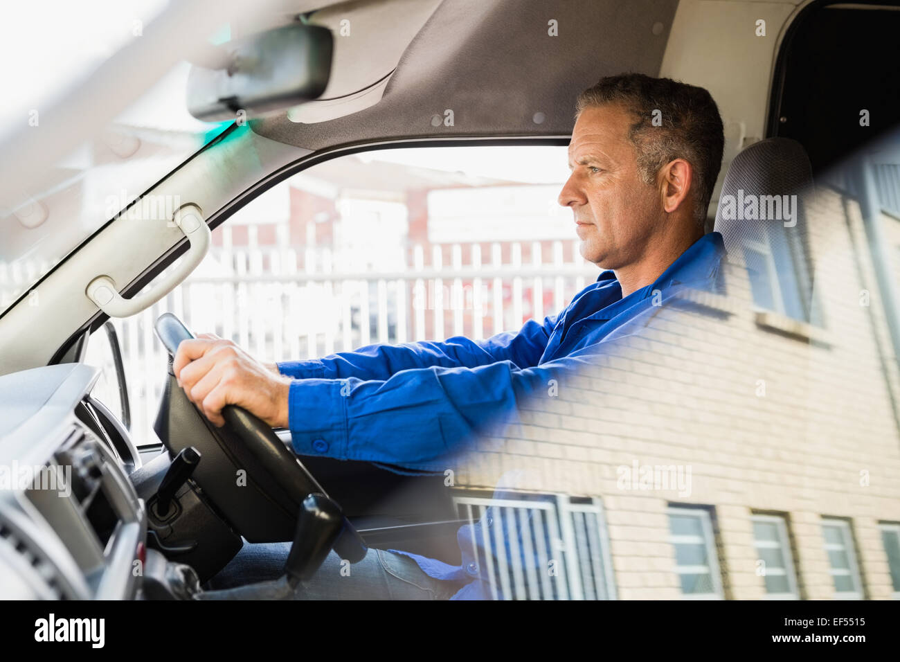 Serious delivery man driving his van Stock Photo - Alamy