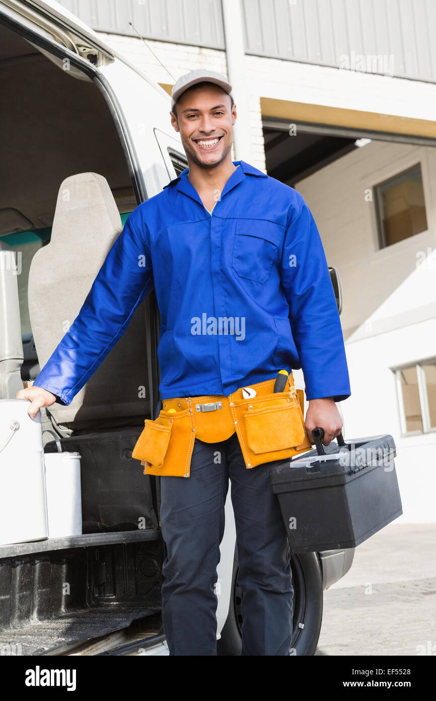 Smiling handsome handyman holding toolbox Stock Photo - Alamy