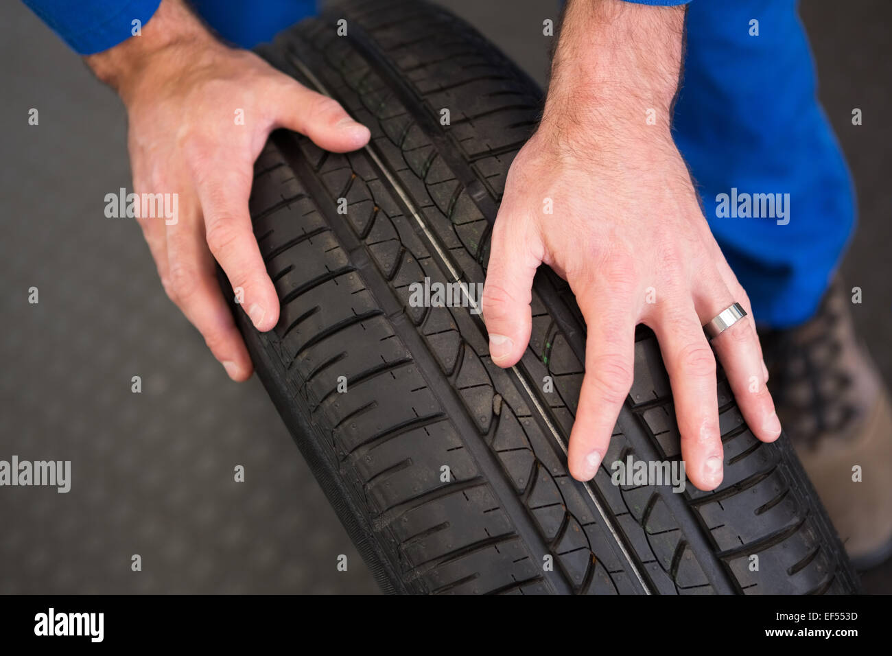 Mechanic rolling tire wheel hi-res stock photography and images - Alamy